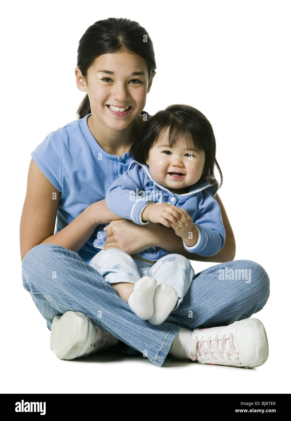 Girl holding child Stock Photo - Alamy