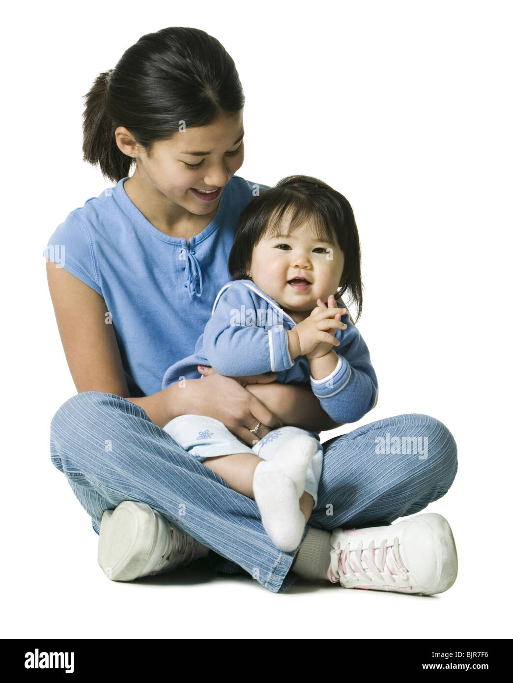 Girl holding child Stock Photo - Alamy