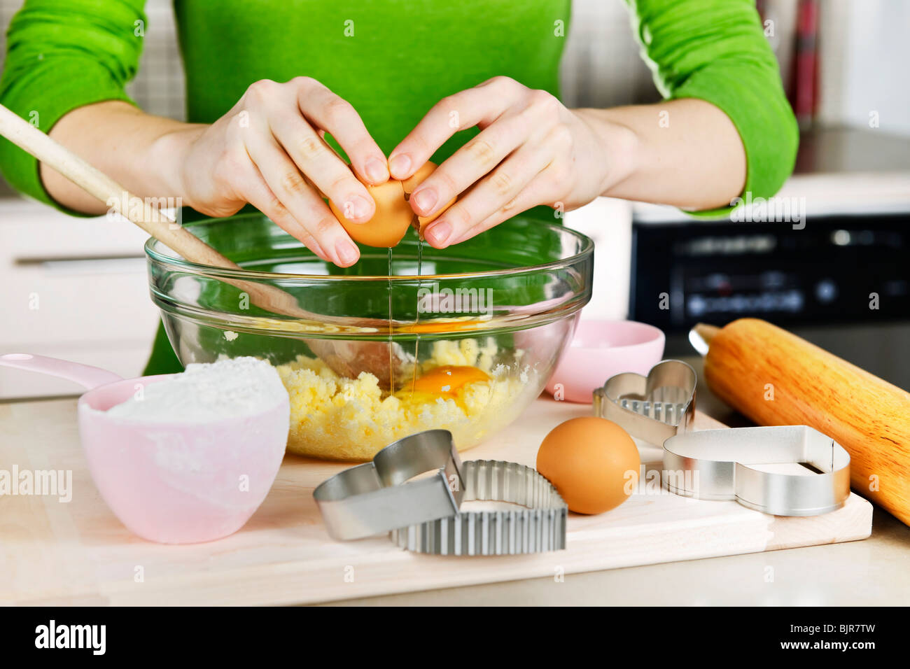 Cracking egg into mixing bowl making cookies Stock Photo - Alamy