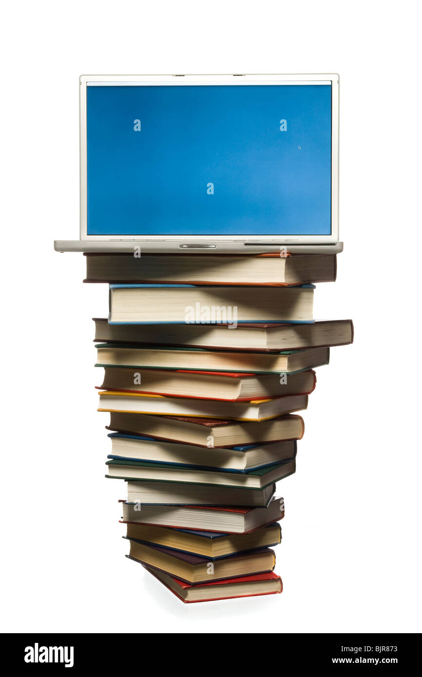 stack of books with a laptop computer on top Stock Photo - Alamy
