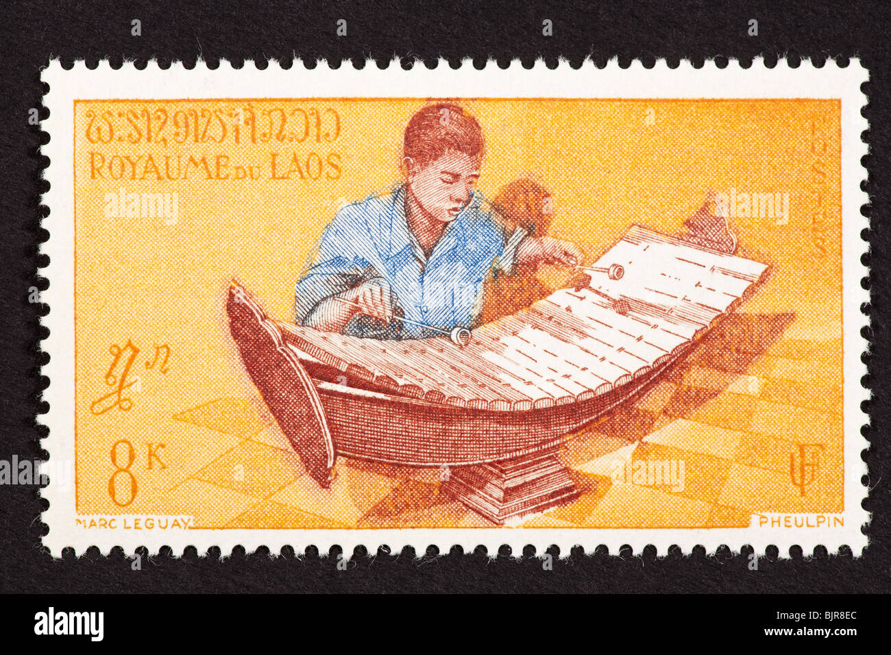 Postage stamp from Laos depicting a man playing a ranat Stock Photo - Alamy
