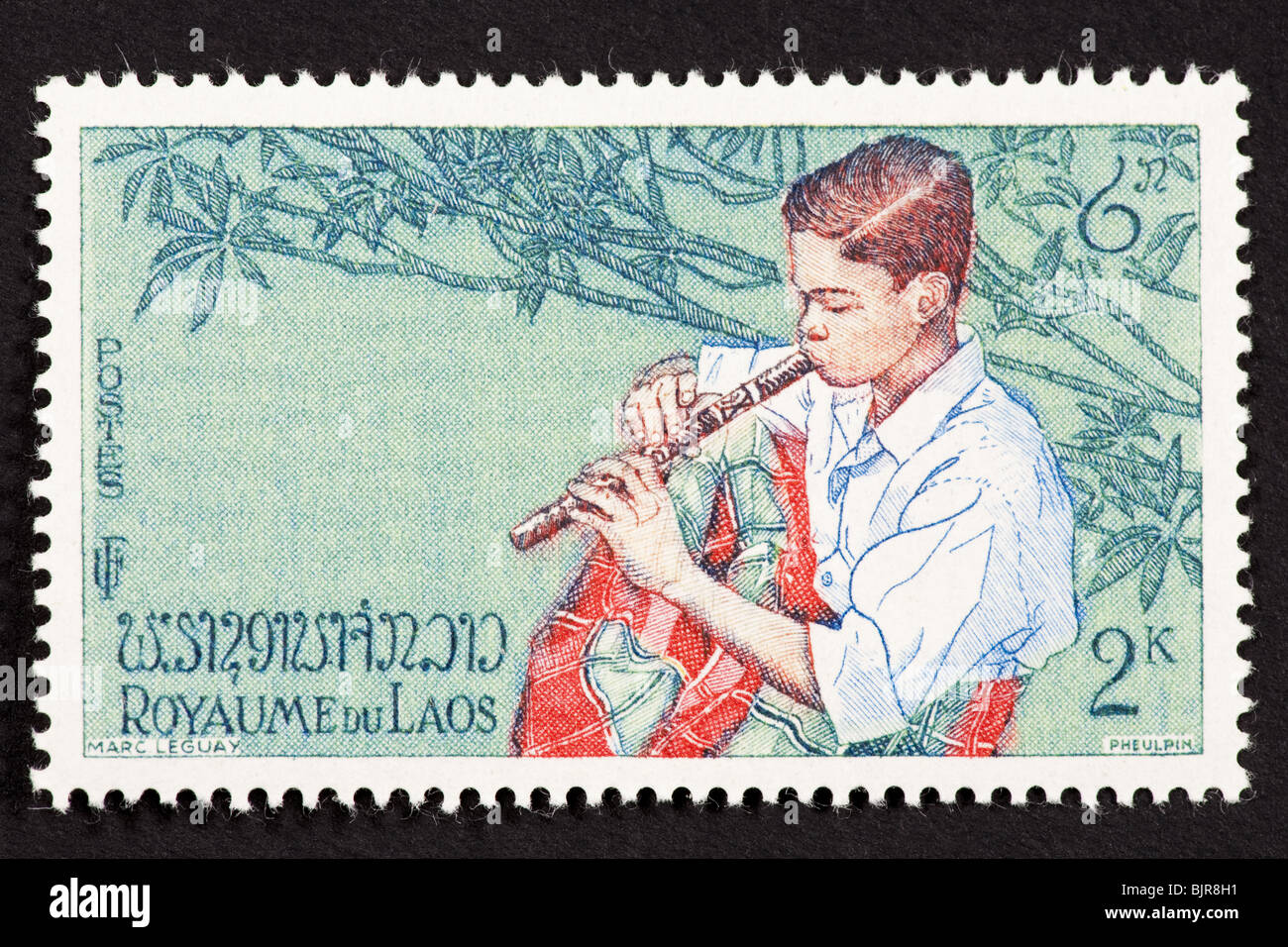 Postage stamp from Laos depicting a man playing a khouy Stock Photo - Alamy