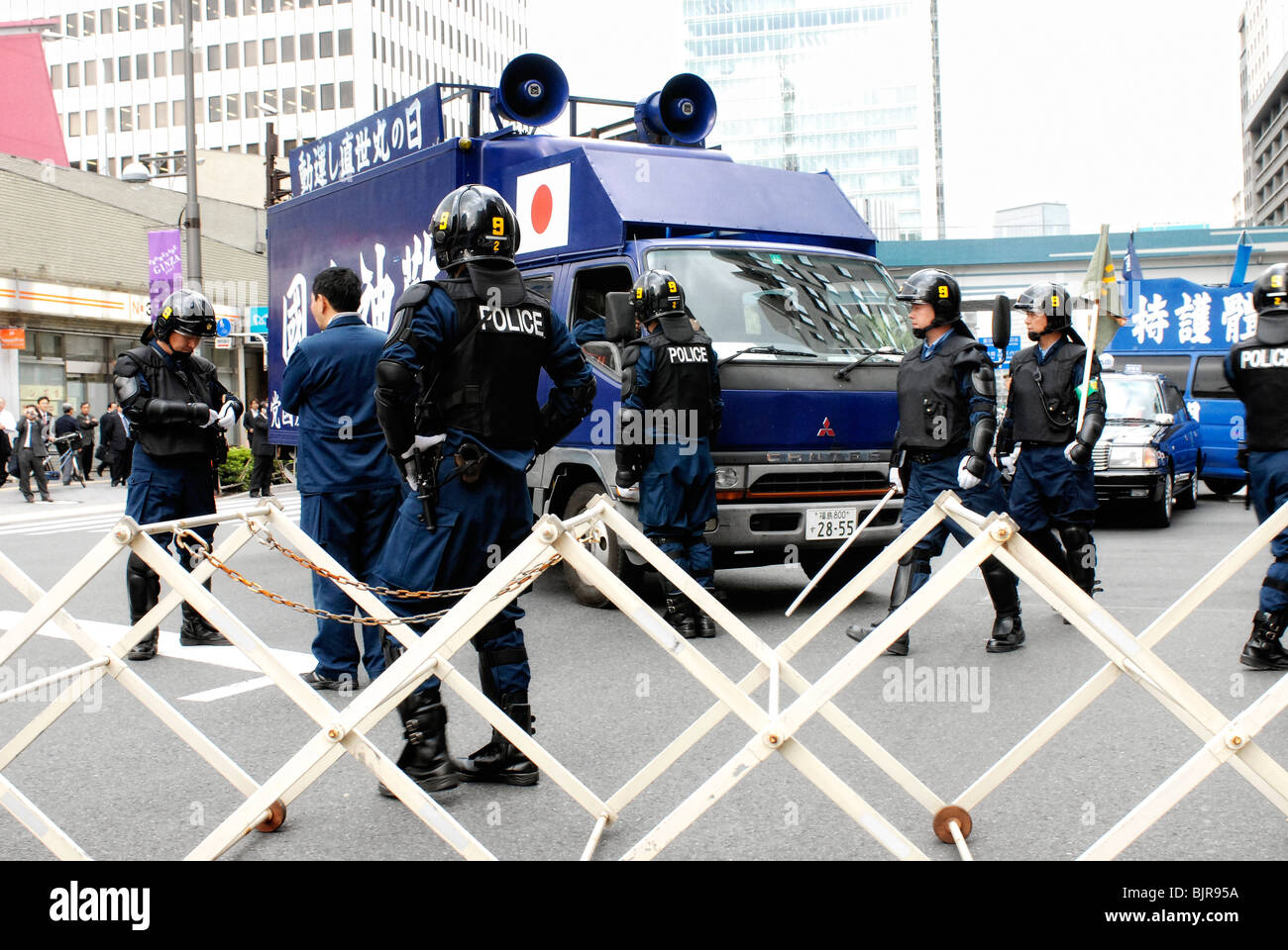 Riot police form a road block to prevent nationalist groups in vans ...
