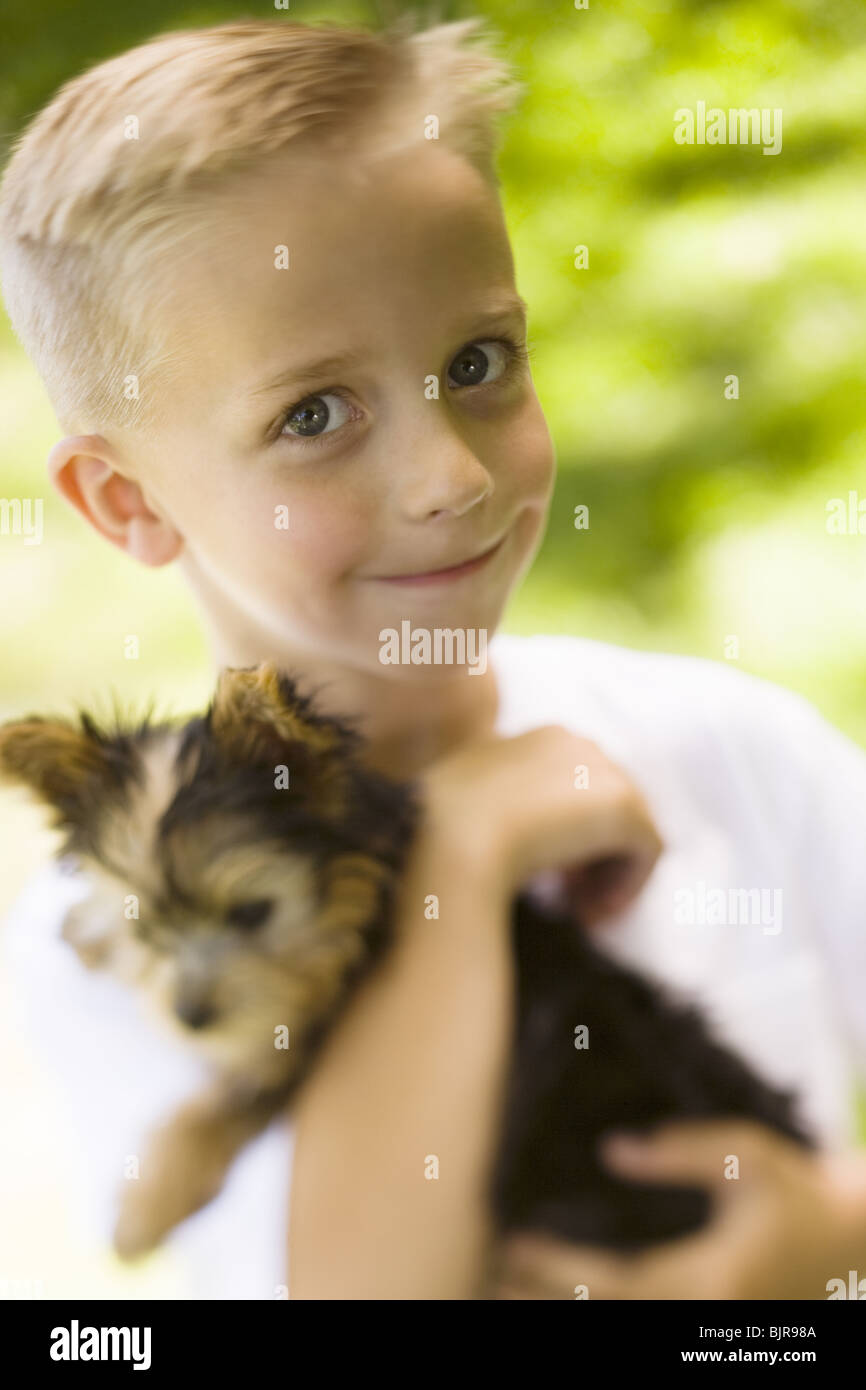 Boy holding small dog Stock Photo - Alamy