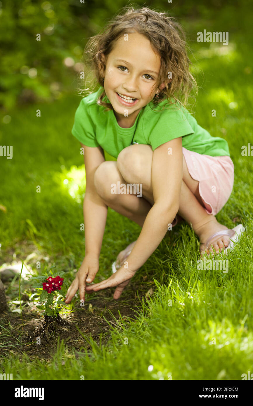 Girl crouching in grass Stock Photo - Alamy