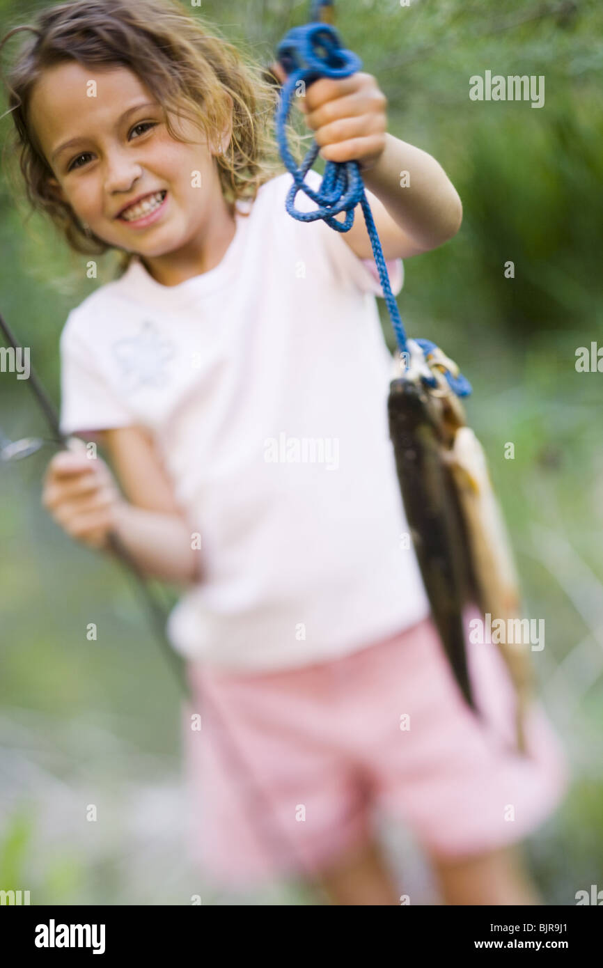 Girl holding fish on cord Stock Photo - Alamy