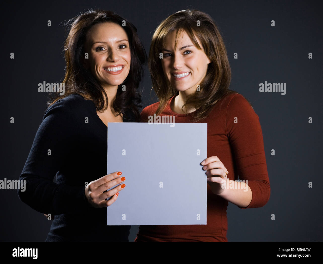 two women holding a sign Stock Photo - Alamy