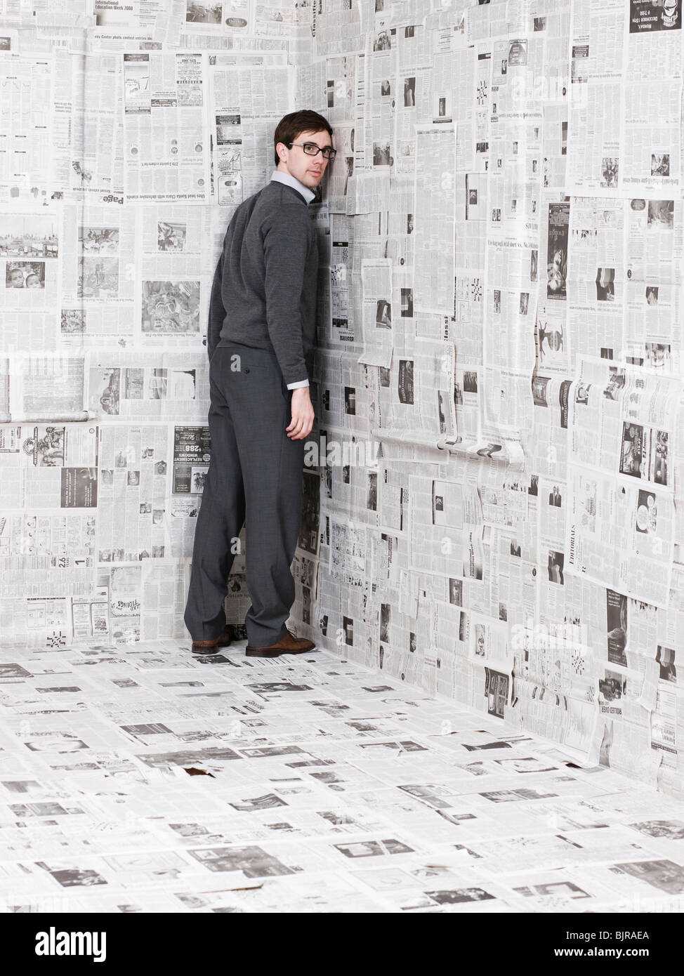 Portrait of young man standing in newspaper room Stock Photo - Alamy
