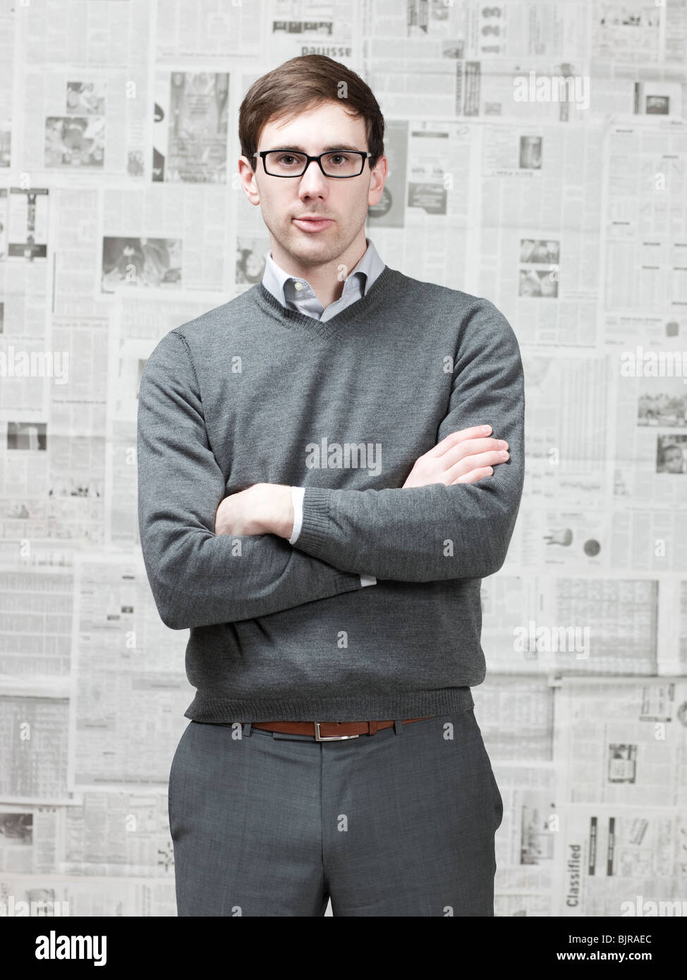 Portrait of young man standing in newspaper room Stock Photo - Alamy
