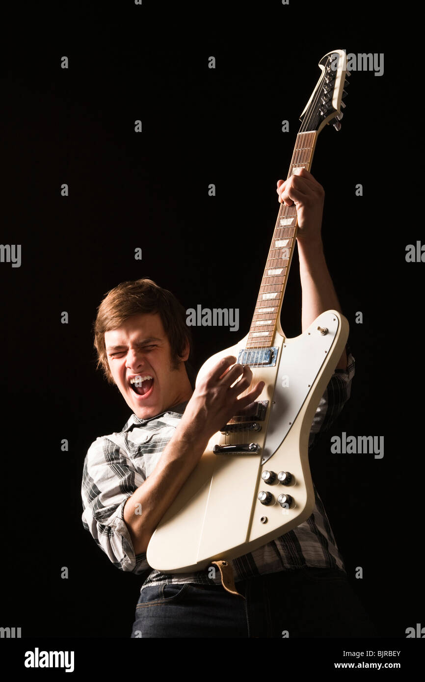 Young man playing electric guitar, studio shot Stock Photo - Alamy