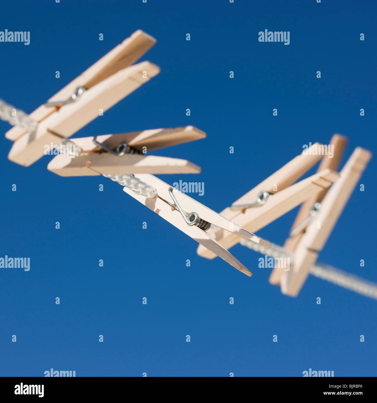 Clothes pegs hanging on washing line Stock Photo - Alamy