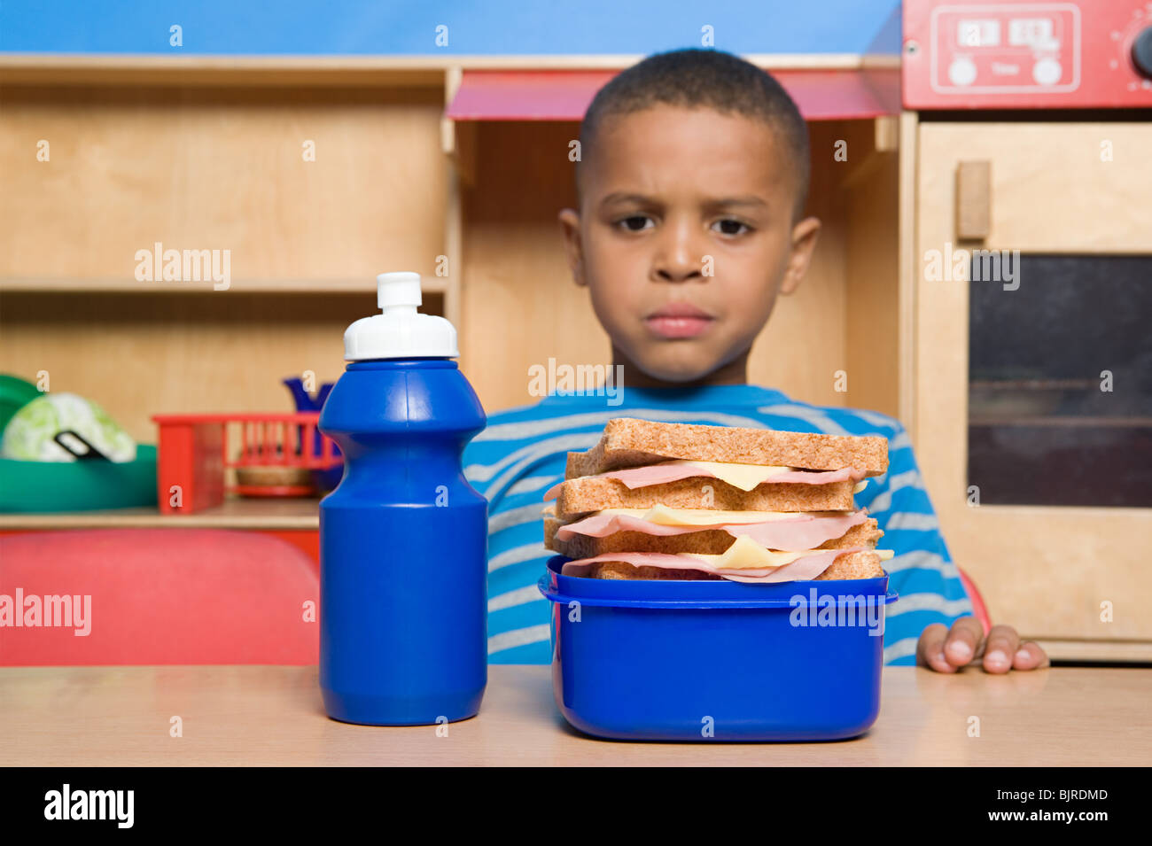 Boy looking at lunch box Stock Photo - Alamy