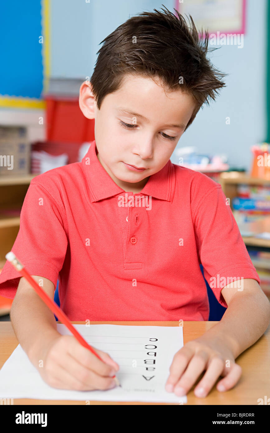 Boy writing alphabet Stock Photo - Alamy