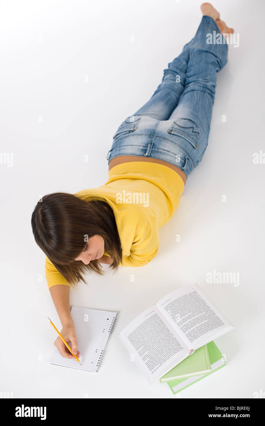 Student - female teenager write homework with book on white background ...