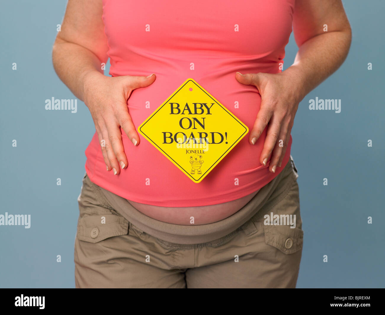 Pregnant woman with sign on stomach Stock Photo - Alamy