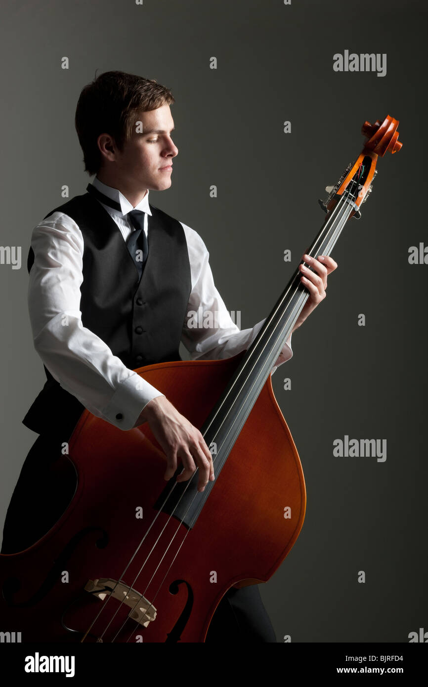 Young man playing double bass, studio shot Stock Photo - Alamy