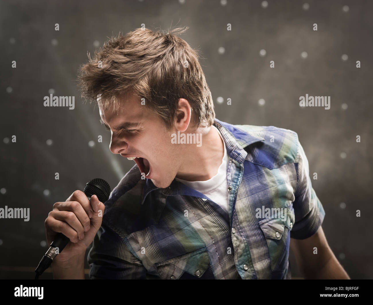 Young man singing, studio shot Stock Photo - Alamy