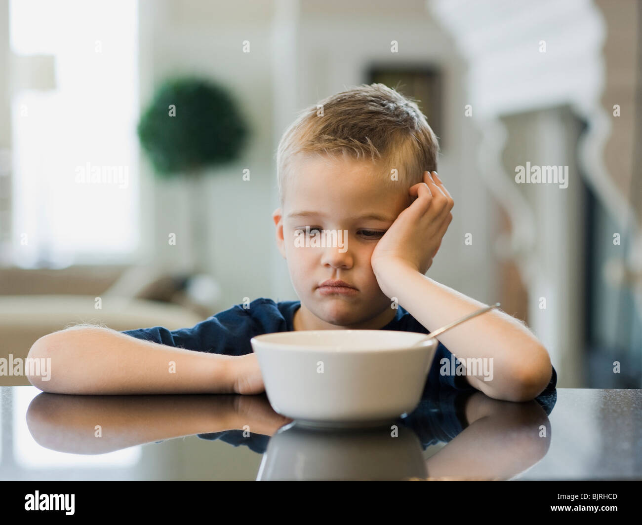 USA, Utah, Alpine, boy (6-7) resting cheek on hand by bowl Stock Photo ...