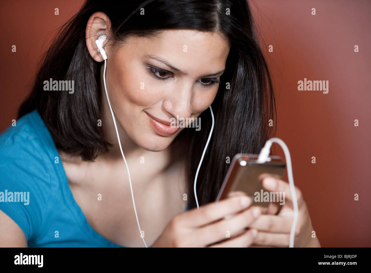Woman listening to MP3 player Stock Photo - Alamy