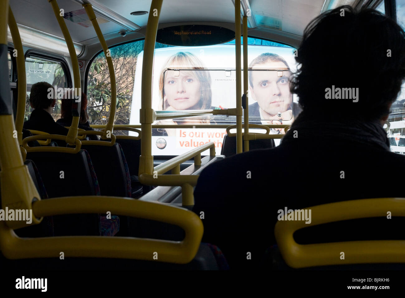 Bus passengers face forward to see large advertising faces on the back ...