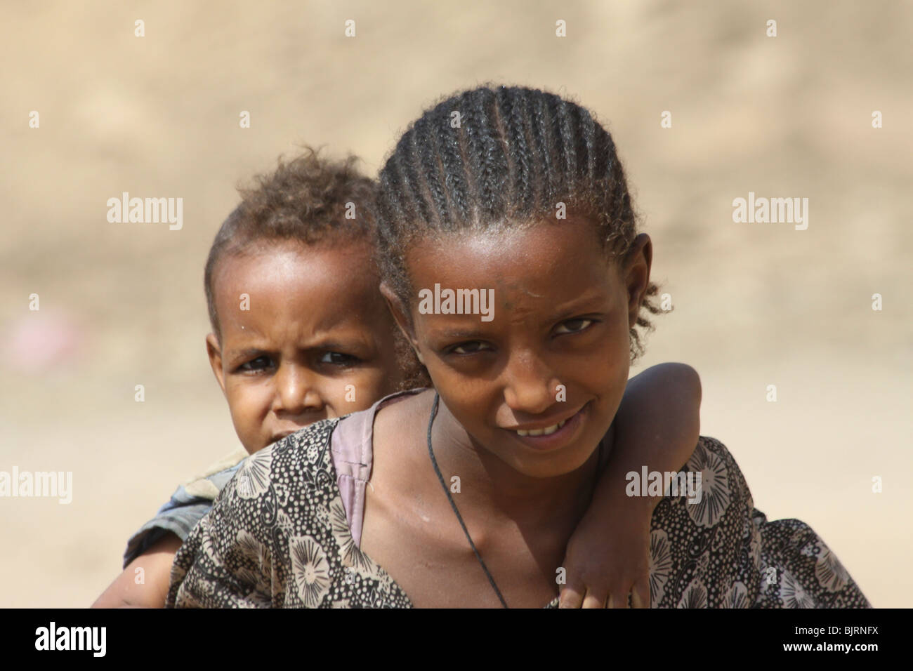 Ethiopia, Tigray Region, Yeha, Young mother with child on her back ...