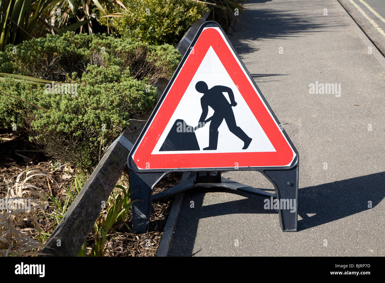 Man at work red triangular road sign Stock Photo - Alamy