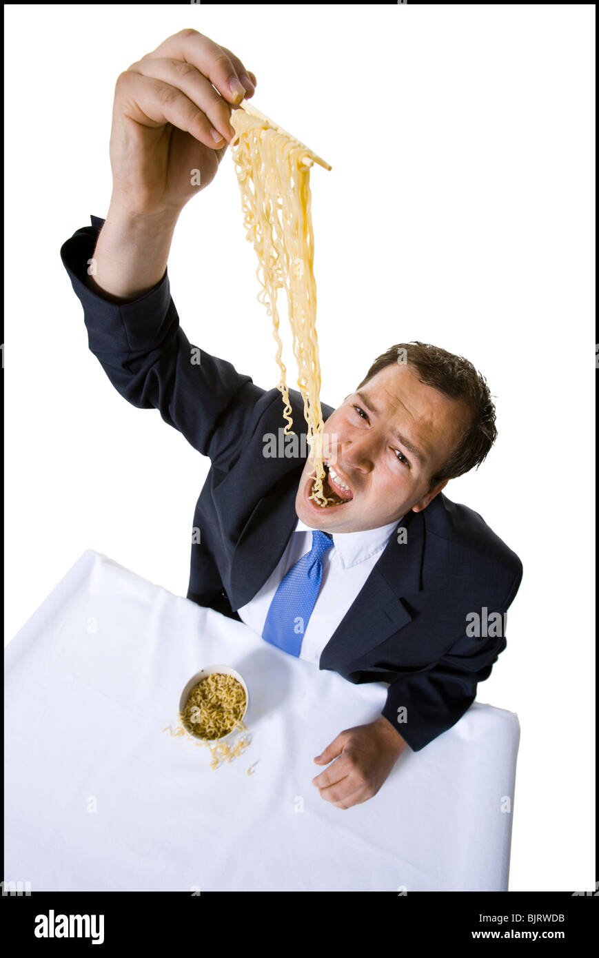 Businessman awkwardly eating noodles Stock Photo - Alamy