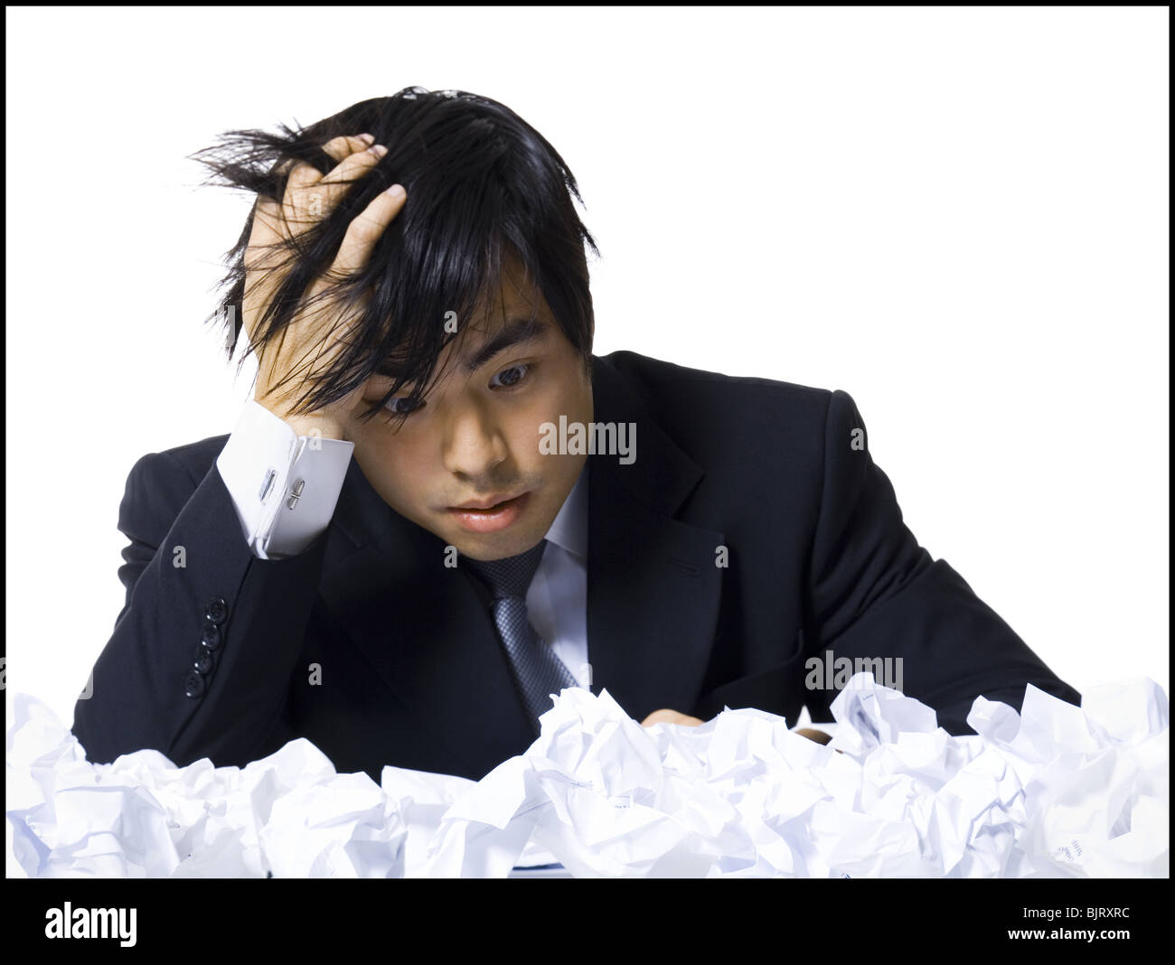 Frustrated businessman surrounded by crumpled papers Stock Photo - Alamy