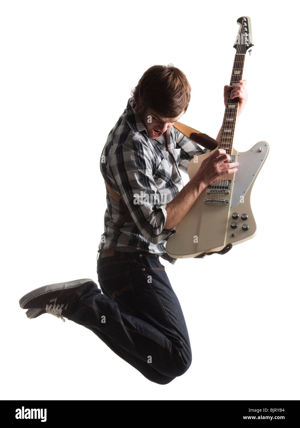 Young man playing electric guitar and jumping Stock Photo - Alamy