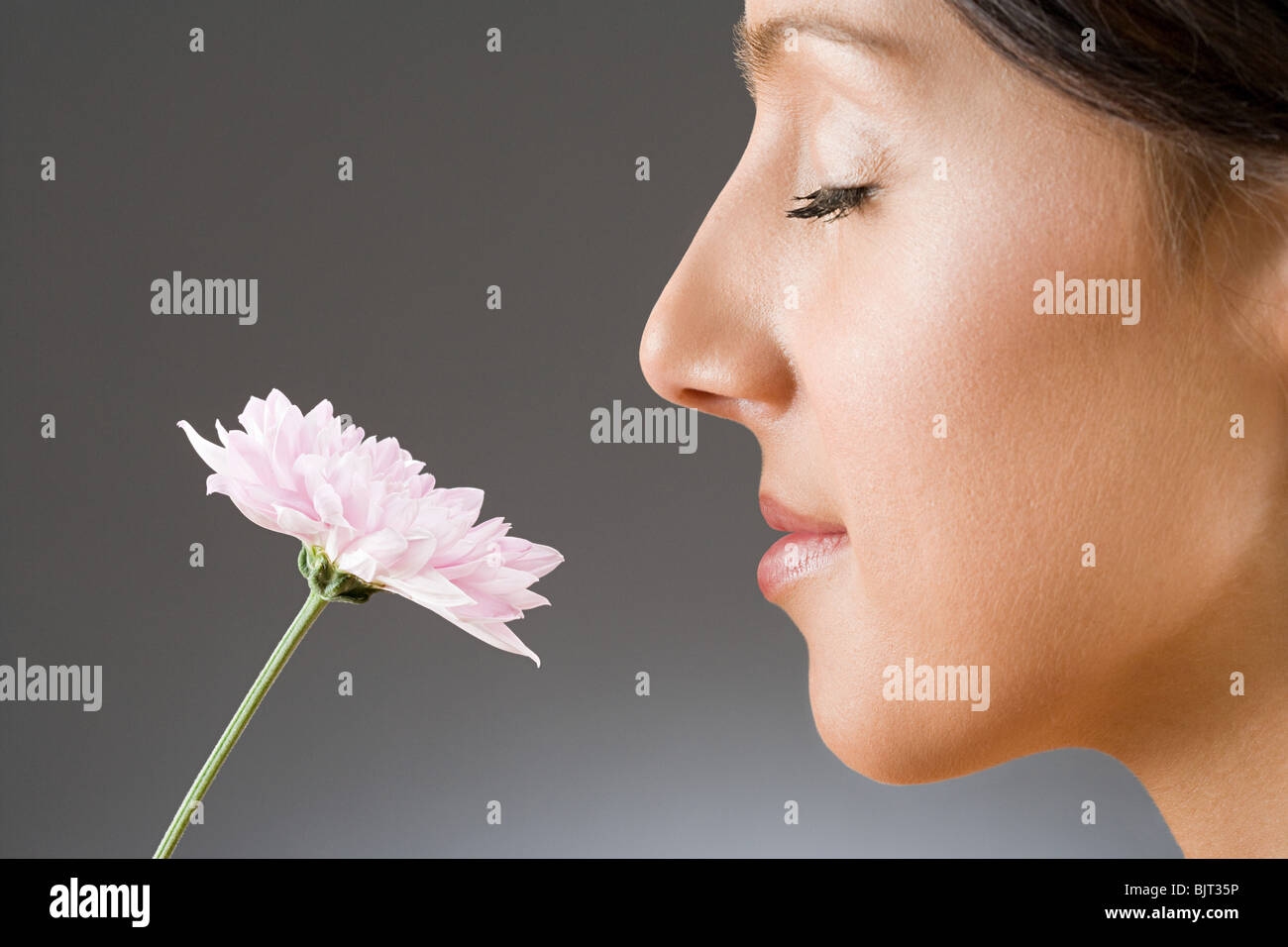 A woman smelling a flower Stock Photo - Alamy