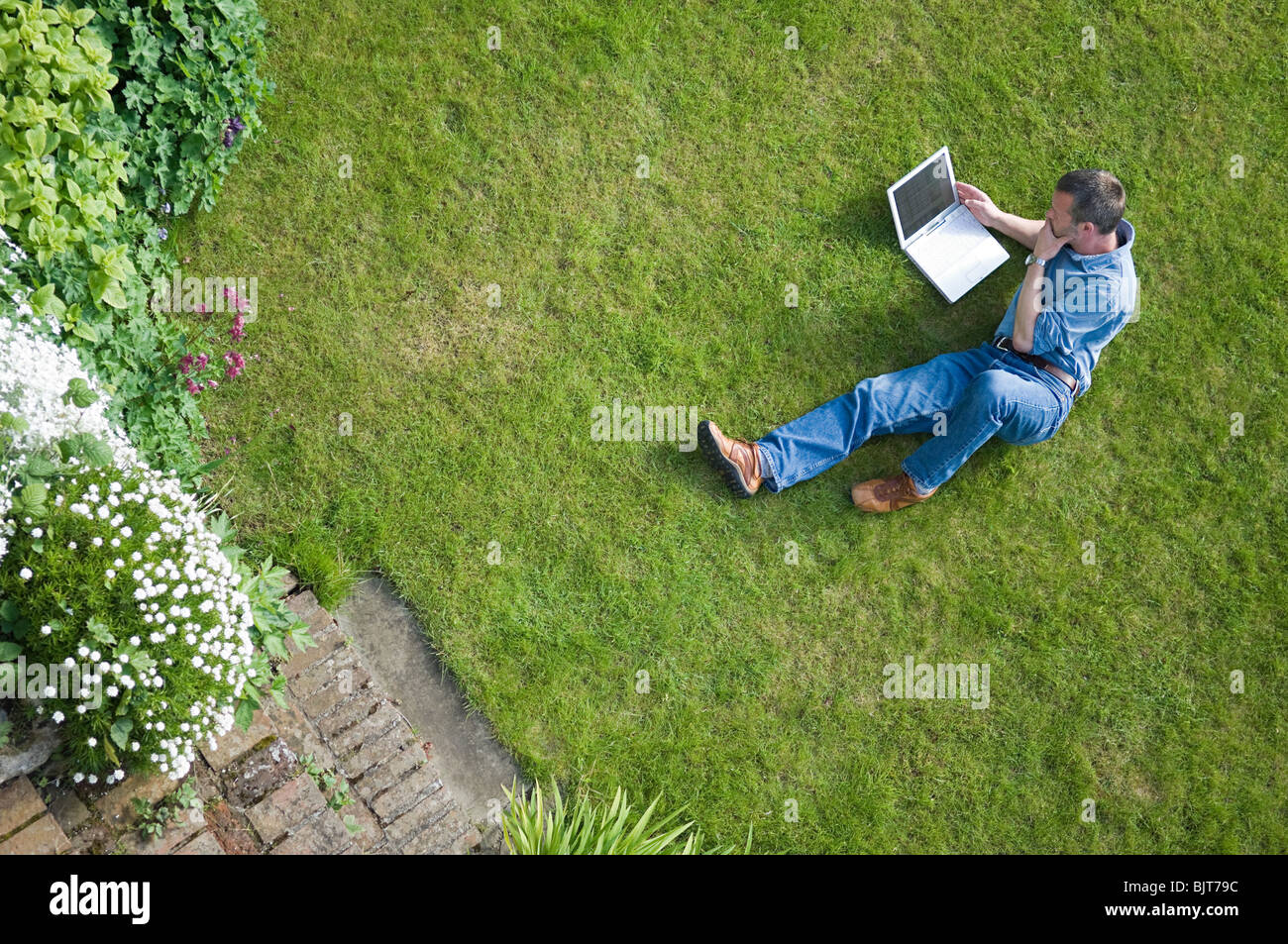 Man with laptop in garden Stock Photo - Alamy