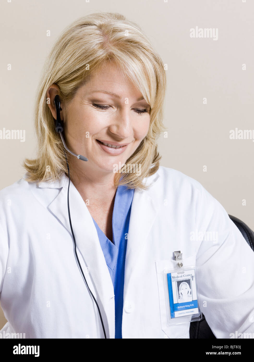 Female nurse using headset, studio shot Stock Photo - Alamy