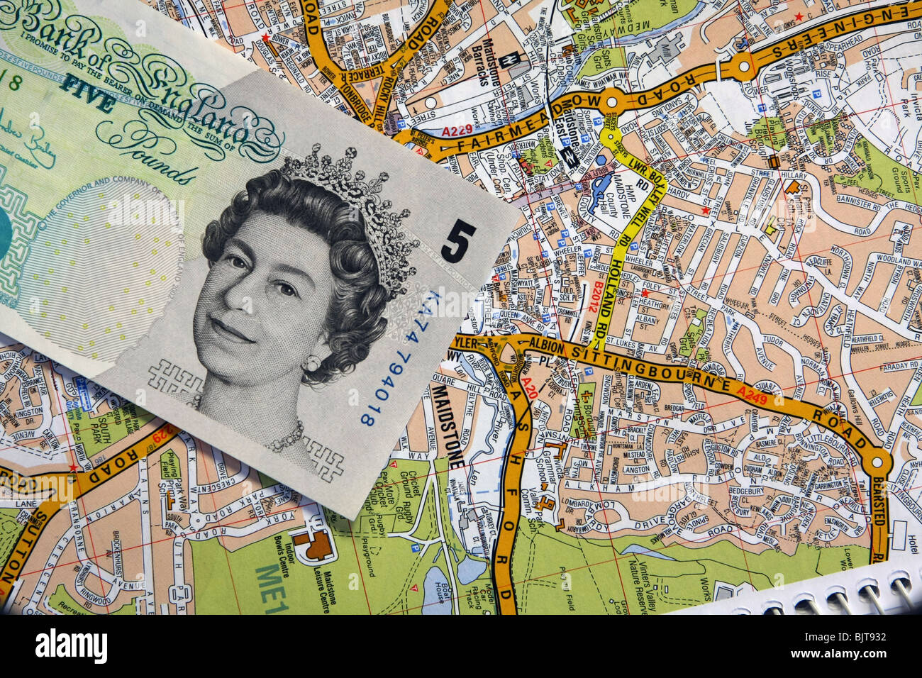 a £5 note on a page of an open road map Stock Photo - Alamy
