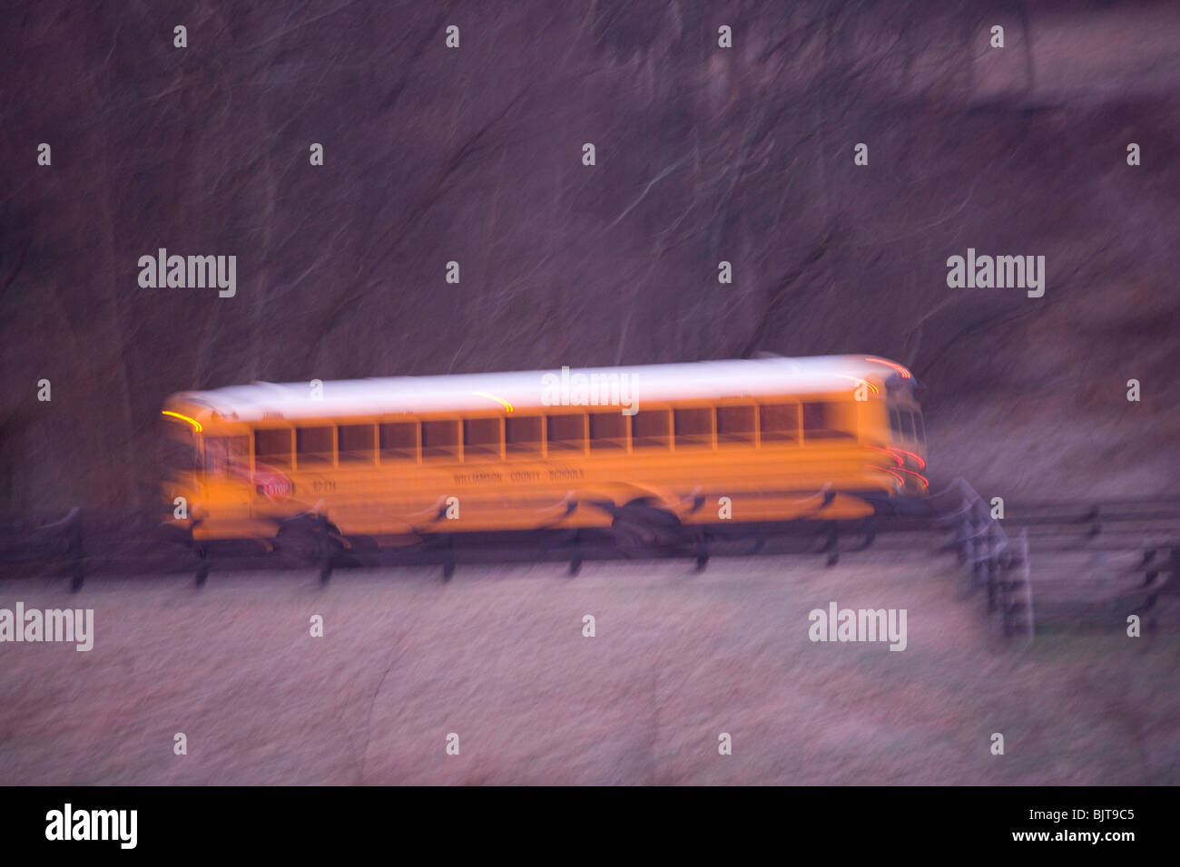 School bus in the early morning making a stop to pick up students ...