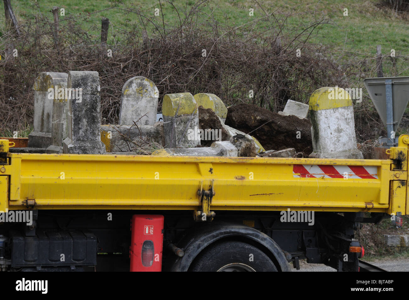 Old kilometre roadstone markers being ripped up and loaded into a lorry ...