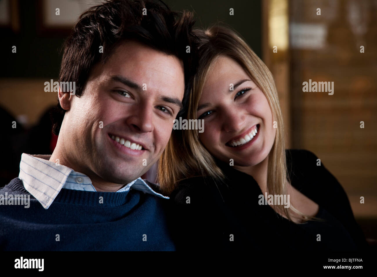 Couple sitting close and smiling Stock Photo - Alamy