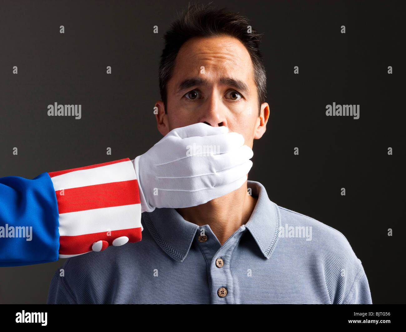 Human hand in Uncle Sam's costume shielding man's mouth, studio shot ...