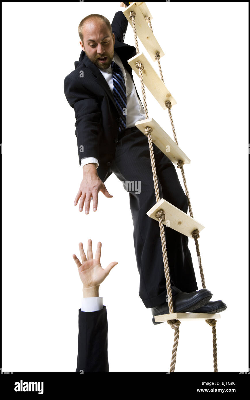 Businessman helping someone up ladder Stock Photo - Alamy