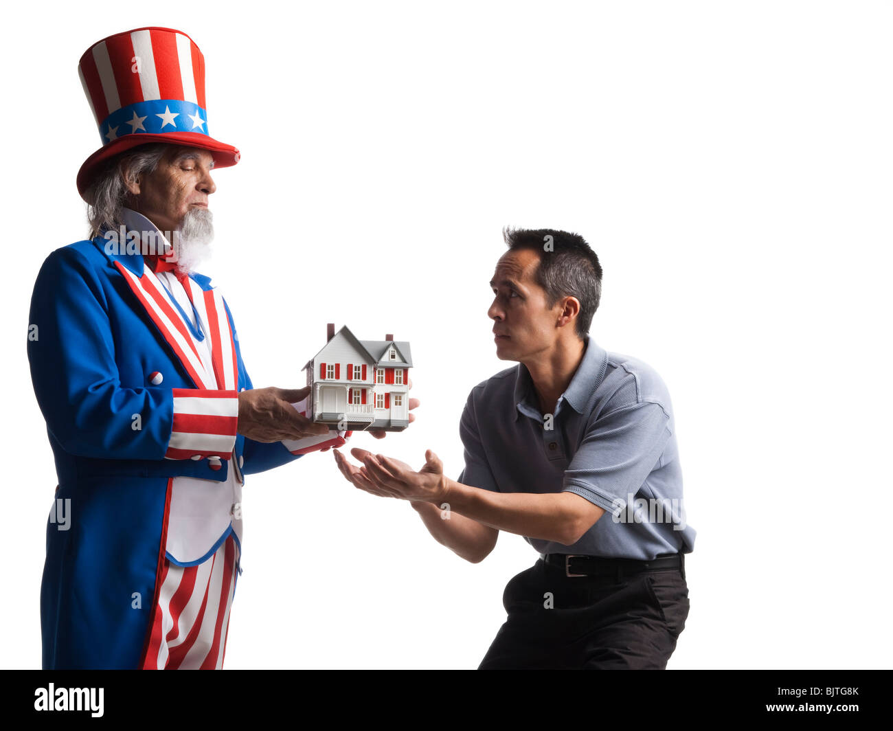 Man in Uncle Sam's costume giving model of house to other man, studio ...
