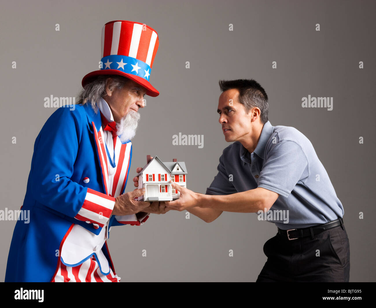Man in Uncle Sam's costume giving model of house to other man, studio ...