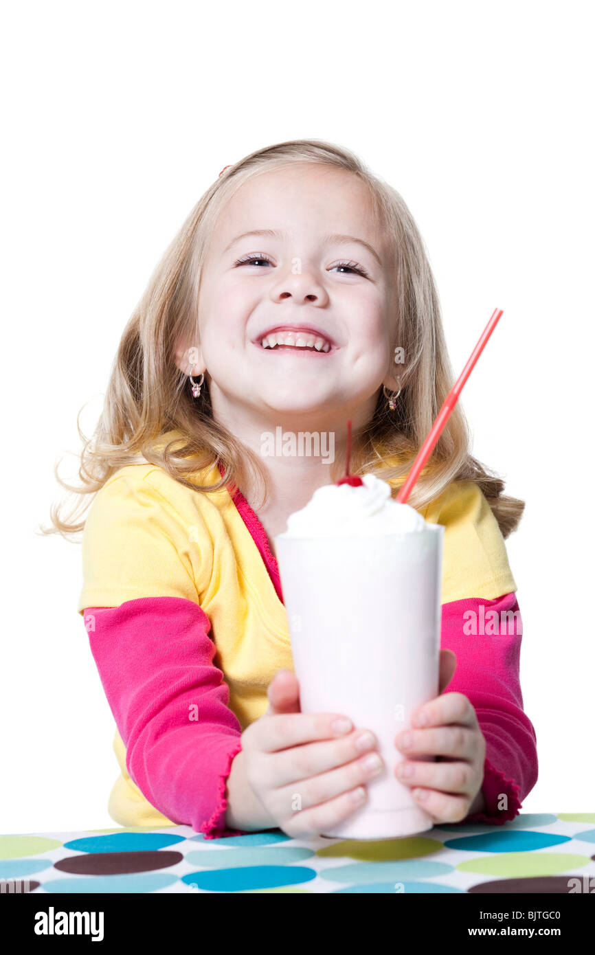 Girl holding milkshake and smiling Stock Photo - Alamy