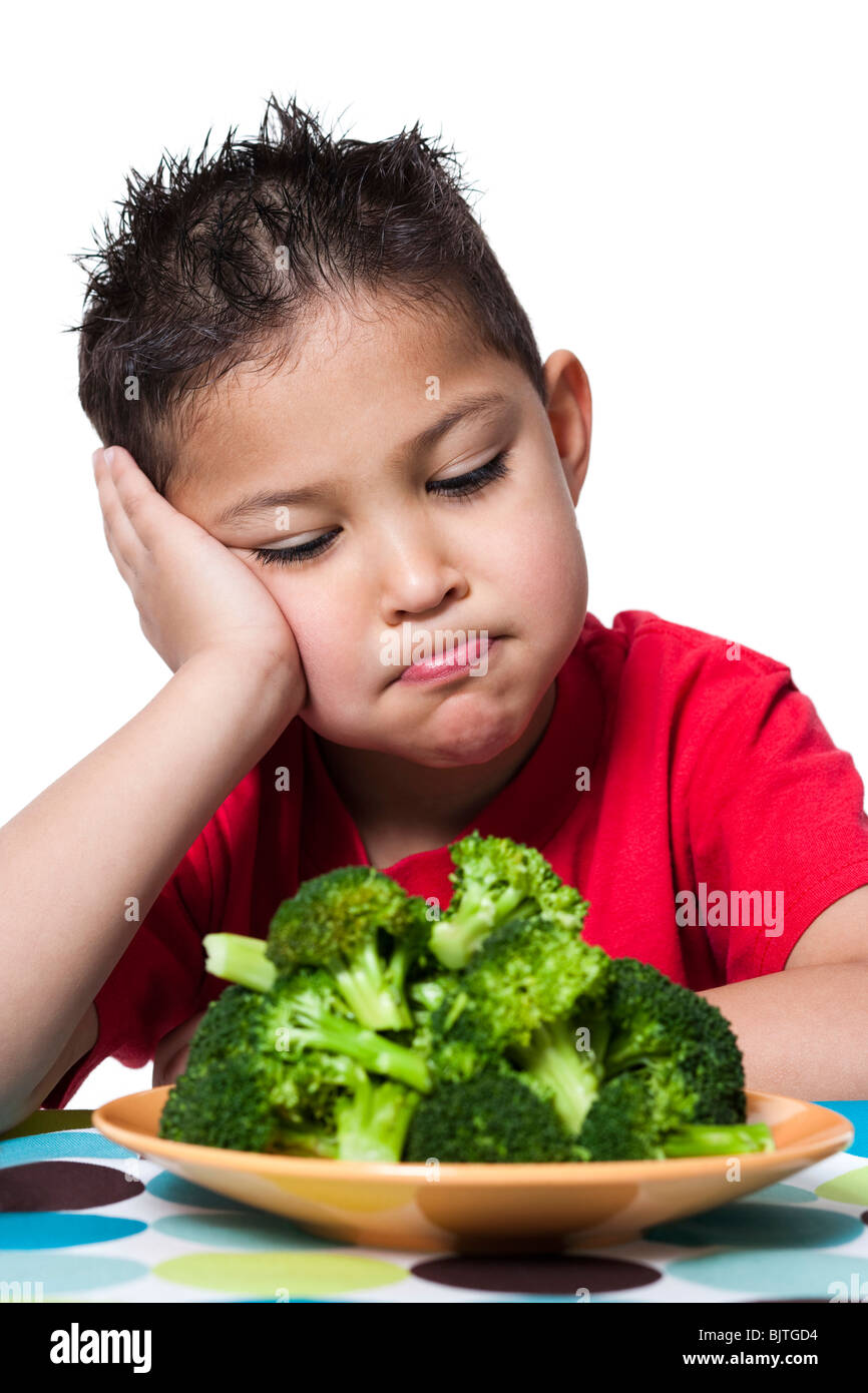 Boy with plate of broccoli frowning Stock Photo - Alamy