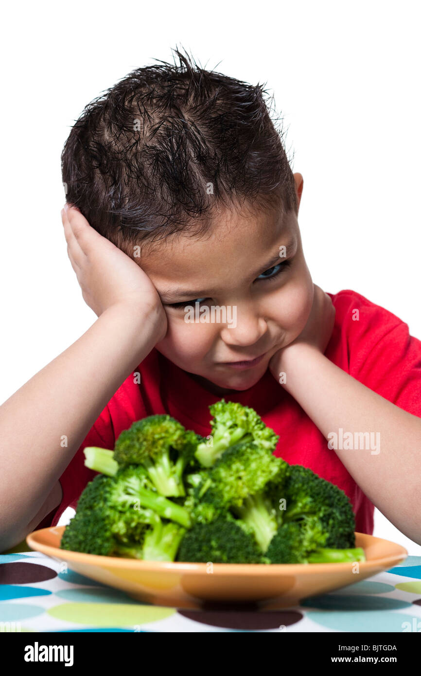 Boy with plate of broccoli frowning Stock Photo - Alamy