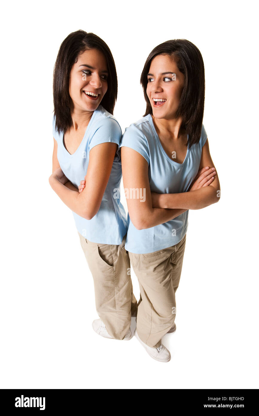 Sisters standing back to back with arms crossed Stock Photo - Alamy