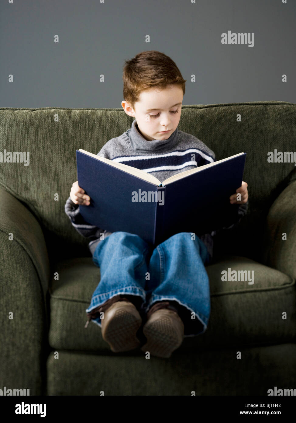 Boy reading book Stock Photo - Alamy