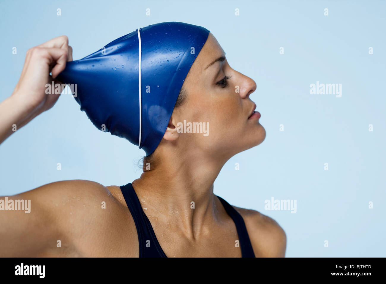 Woman pulling off bathing cap Stock Photo - Alamy