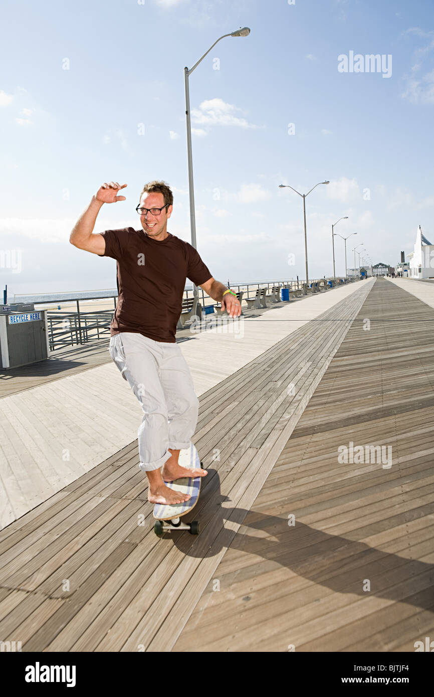 Man skateboarding on boardwalk Stock Photo - Alamy