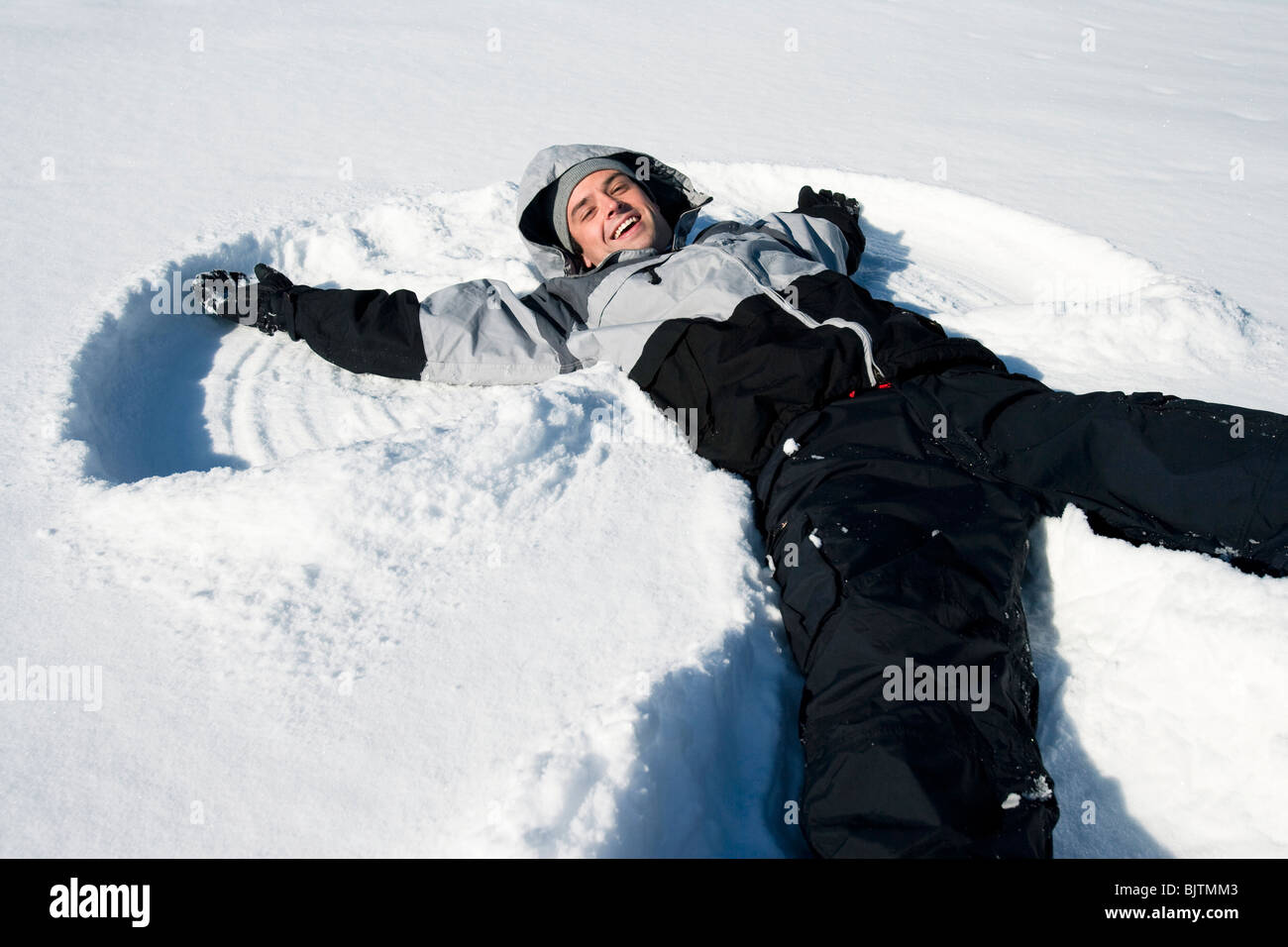 Man making snow angel Stock Photo - Alamy