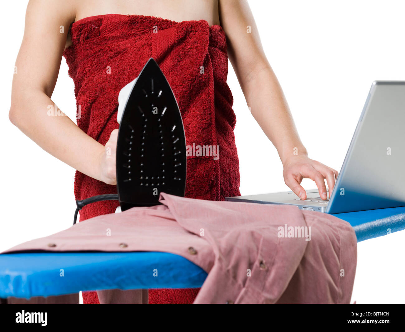 Woman ironing and working on laptop Stock Photo - Alamy
