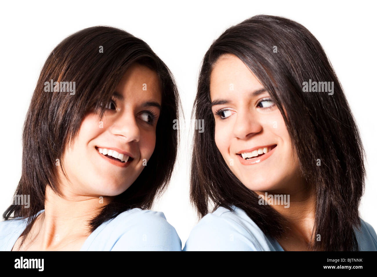 Sisters back to back with arms crossed Stock Photo - Alamy